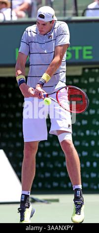John Isner returns a ball hit by Alexander Zverev at the Miami Open on ...