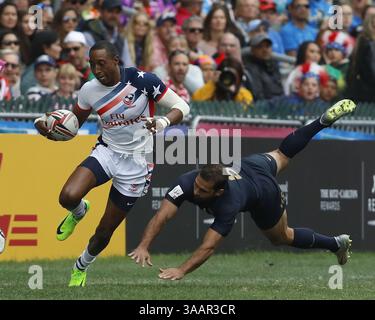 Perry Baker of the United States scores a try as Britain's Dan Bibby ...