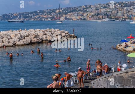 Naples, Italy - August 04, 2024: People swimming and sunbathing on a ...