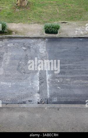Close-up of a road resurfacing process showing the contrast between old ...