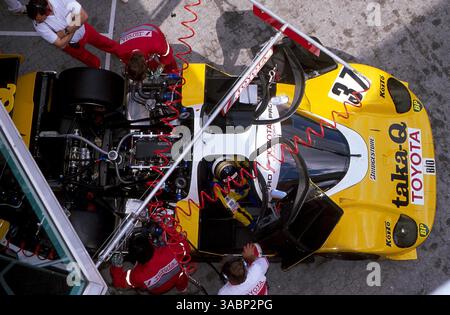 F1 mechanics at work on a Toyota F1 race car in the pit lane workshop ...