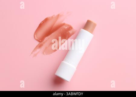 Pink moisturizing hygienic lipstick on a podium on a blue background ...