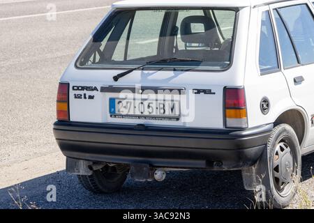 Classic white opel corsa 1.2l cat parked on the side of a paved road ...