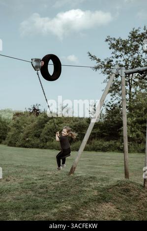 Girl is playing at cableway at playground. ridding at ropeway Stock ...