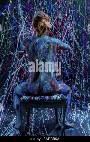 A model poses gracefully, her body adorned in vibrant body paint, with ...