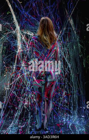 A model poses gracefully, her body adorned in vibrant body paint, with ...