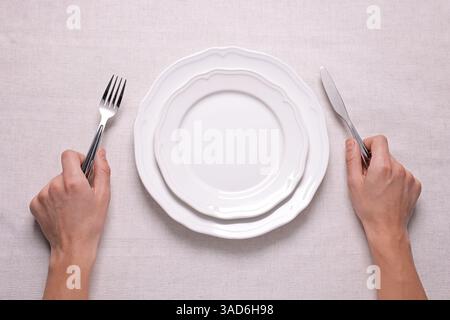 Man with cutlery and clean plates at table, top view Stock Photo - Alamy