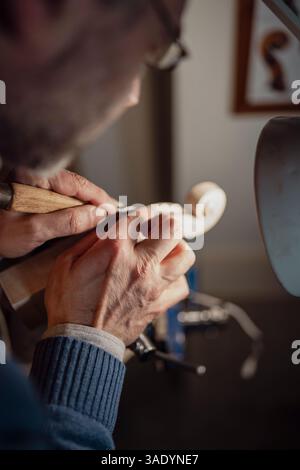 close-up of a luthier's hands at work on the body of a guitar, hands of ...