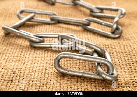 A piece of metal chain on jute cloth, macro, top view Stock Photo - Alamy