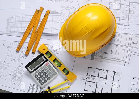 Hard hat, divider, calculator, folding ruler and building level on ...
