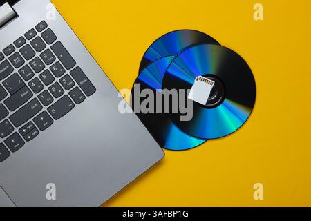 SD memory card, cd drives on yellow paper background. Modern and ...