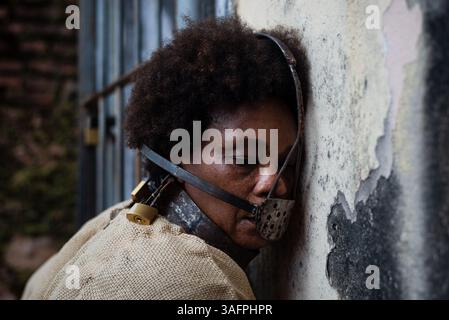 Black woman in chains with an iron mask on her face, representing the ...