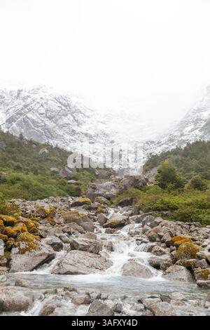 Beautiful view of stream amidst snow covered mountains in valley ...