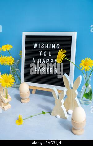 Letter board with message WISHING YOU A HAPPY EASTER on festive blue ...