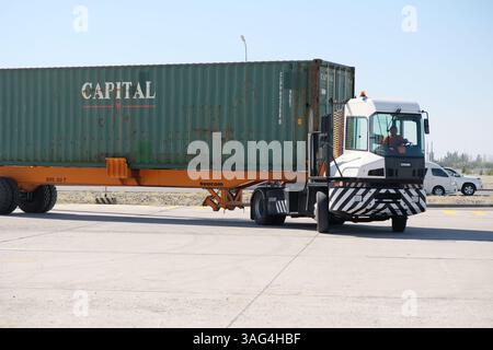 Unloading containers at the logistics center. Machines and cranes drag ...