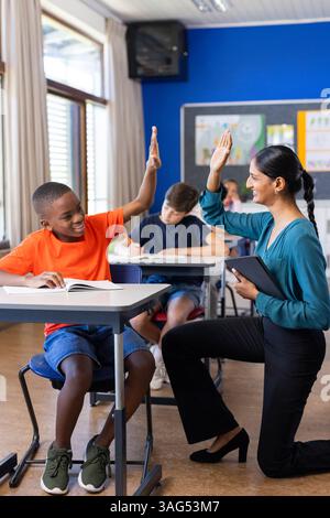High-fiving student, Indian female teacher celebrating success in ...