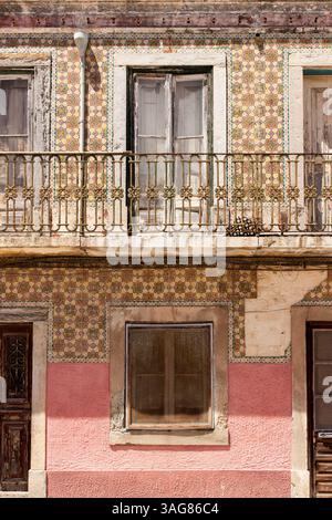 Colorful traditional facades line a quiet street in Lisbon, Portugal ...