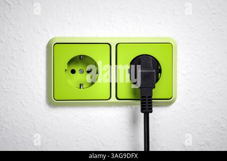 Green outlet with a plug on a wall isolated on white Stock Photo - Alamy