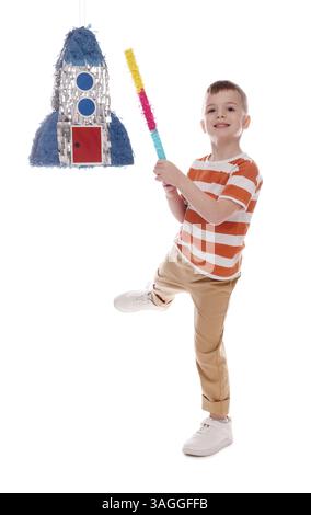 Happy boy breaking rocket shaped pinata with stick on light blue ...