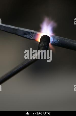 Israeli blacksmith Amit Har-lev heats up a metal rod that he will shape ...