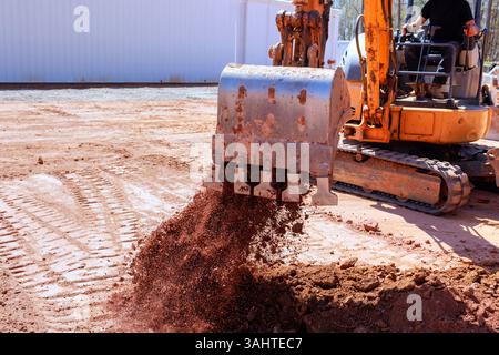 Heavy machinery digs moves dirt at construction site surrounded by ...