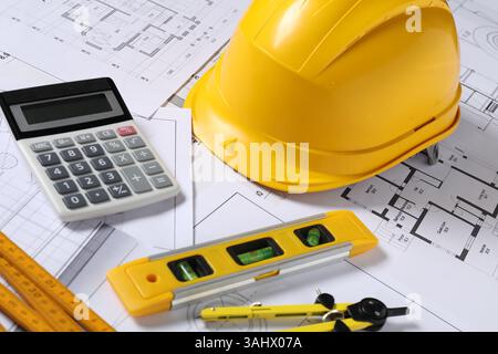 Hard hat, divider, calculator, folding ruler and building level on ...