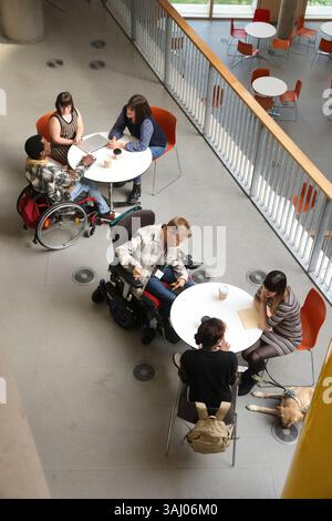 Disabled people talking at tables Stock Photo - Alamy