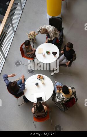 Disabled people talking at tables Stock Photo - Alamy