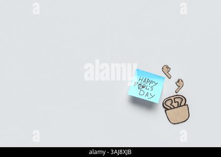 Sticky note and carton earphones on white background. April Fools Day ...