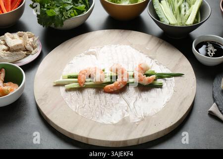 Rice paper sheets and different ingredients on dark grey table, closeup ...
