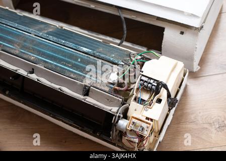 Dirty and disassembled wall-mounted air conditioner unit, showing ...