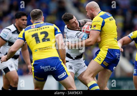 Hull FC's Cade Cust is tackled by Wigan Warriors' Ethan Havard, during ...