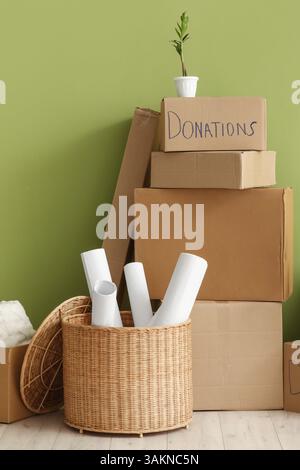 Cardboard boxes for donations near green wall in room Stock Photo - Alamy