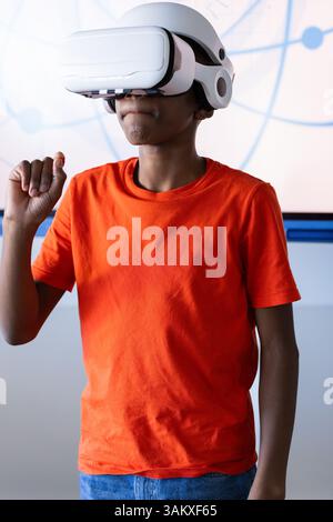Using VR headset, boy exploring virtual reality in school classroom ...