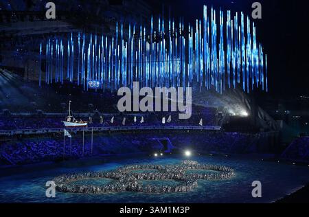 Performers in mirrored costumes form the Olympic rings under a ...