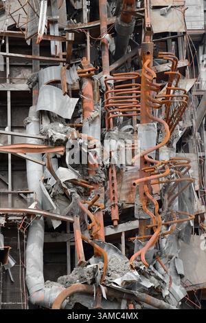 A massive building being dismantled - exposed pipes, burst walls and ...