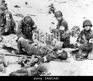 Normandy, France: June 7, 1944. Medics gving plasma on the beach to a ...