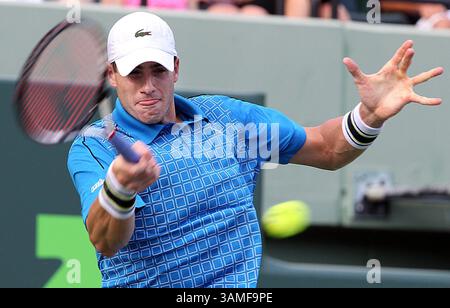 John Isner returns against Donald Young during the second round of the ...