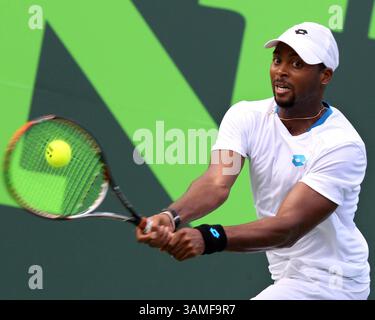 John Isner returns against Donald Young during the second round of the ...
