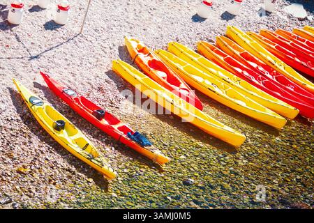 A red kayak rests on the clear water in Riomaggiore, Cinque Terre. The ...