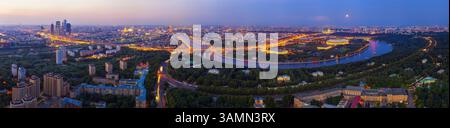Aerial view of beautiful skyscrapers along the river at sunset sky ...