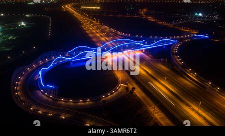 Aerial view of the illuminated Meydan bridge at night in Dubai, United ...