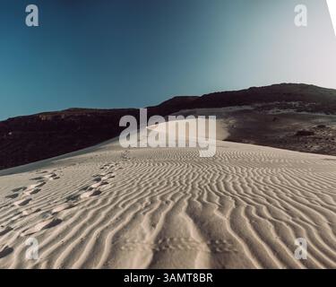 Footprints trail across wind-sculpted sand dunes on Delisha Beach ...