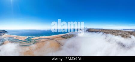 Aerial view of golden sands meet the tranquil sea, with grassy dunes ...