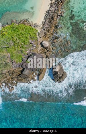 Aerial overhead view of beautiful breaking ocean waves against a rugged ...
