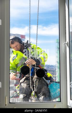 Professional Window Cleaner Performing High-Rise Maintenance on ...