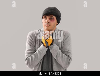 Young homeless man on light background Stock Photo - Alamy