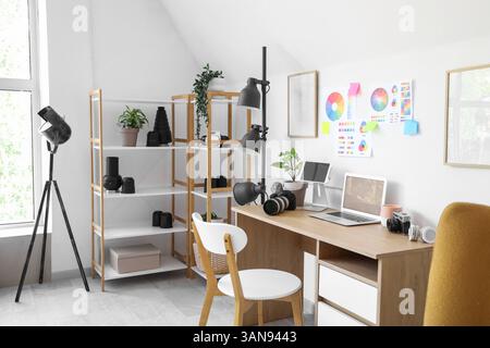 Photographer workplace with laptop, color wheel charts and cameras in ...