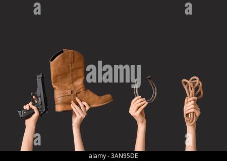 Female hands with gun, horseshoe, lasso and flag of USA on dark ...