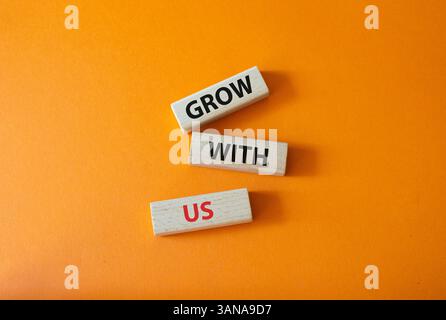 Grow with us symbol. Wooden blocks with words Grow with us. Beautiful ...